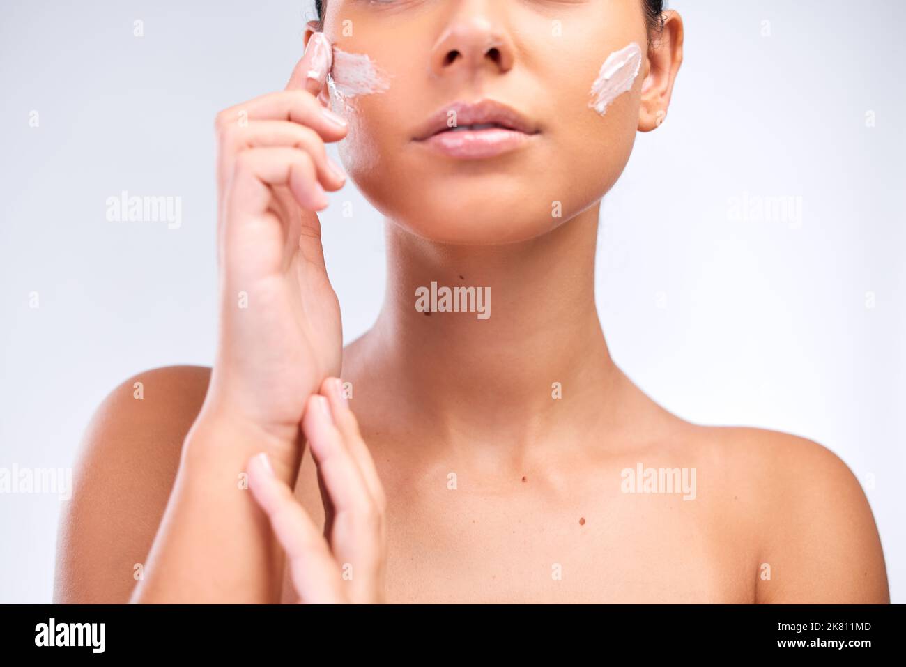 Skin needs moisture to survive. a beautiful young woman applying ...