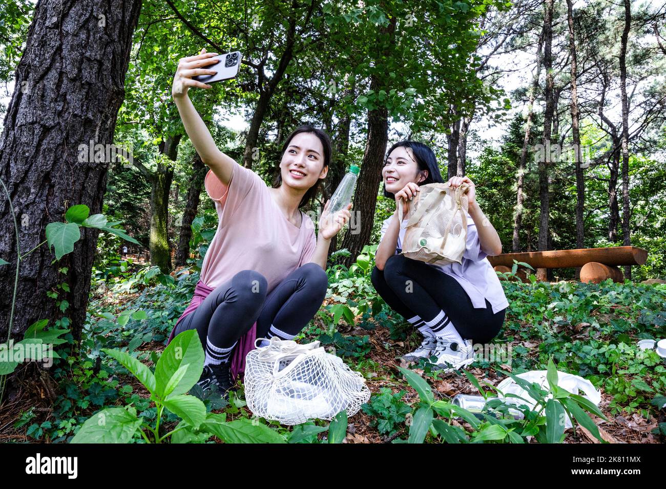korean young women hiking and plogging picking up litter, garbage with ...