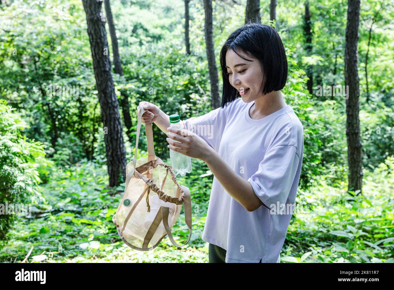 korean young woman hiking and plogging picking up litter, garbage Stock ...
