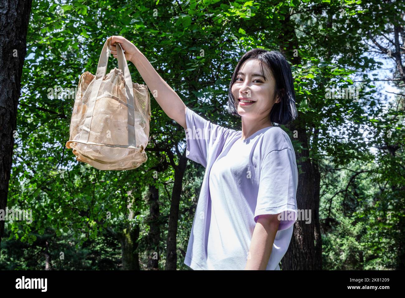 korean young woman hiking and plogging picking up litter, garbage Stock ...