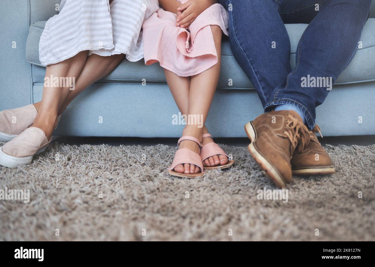 Feet of mom, dad and kid on sofa watching tv, bonding and relax on ...