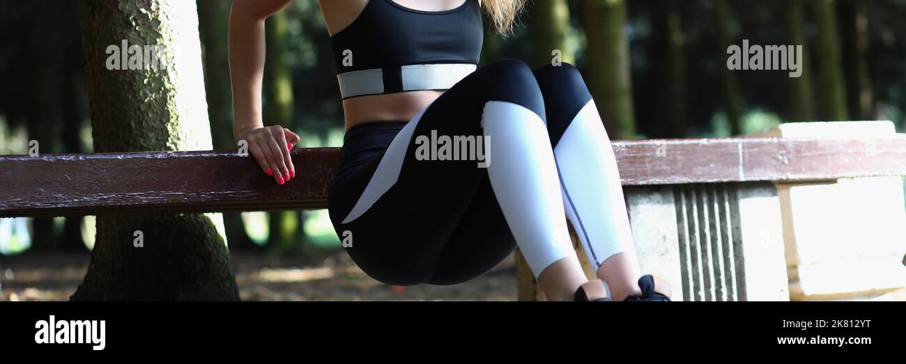 Serious sweaty girl doing push ups on bench in park, work hard on ...