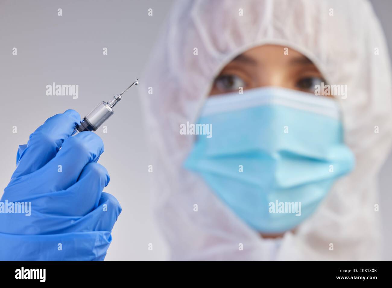 Protect yourself with this. a young female nurse holding a needle ...