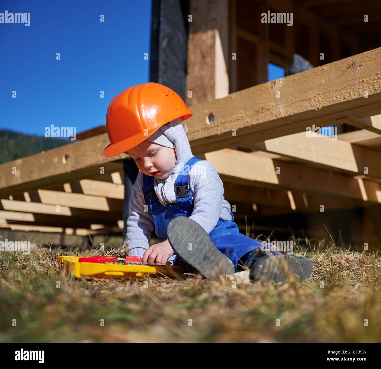 Boy toddler playing as builder on construction site. Child carpenter in ...