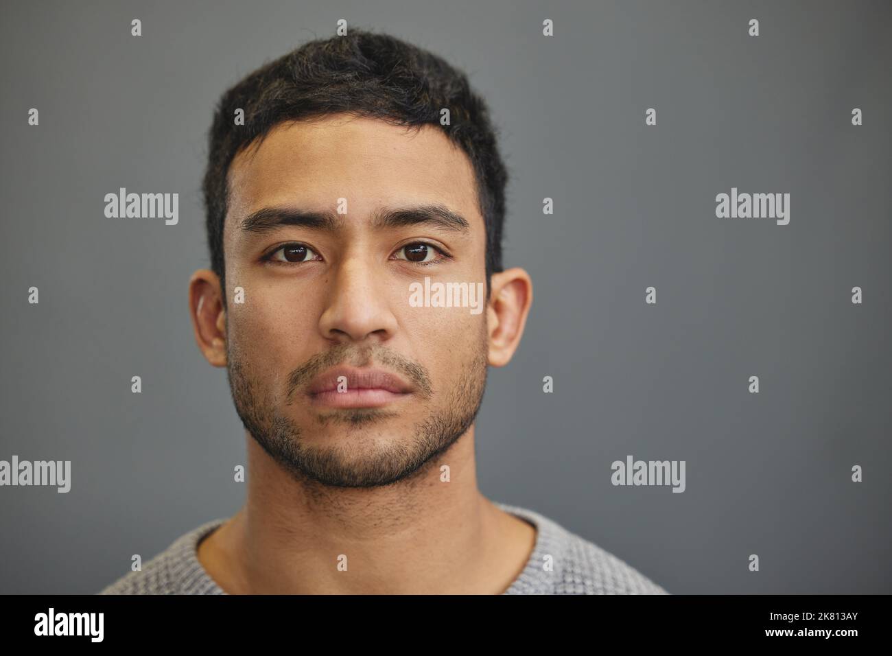 Im trying hard to hide my feelings. a handsome young man standing ...