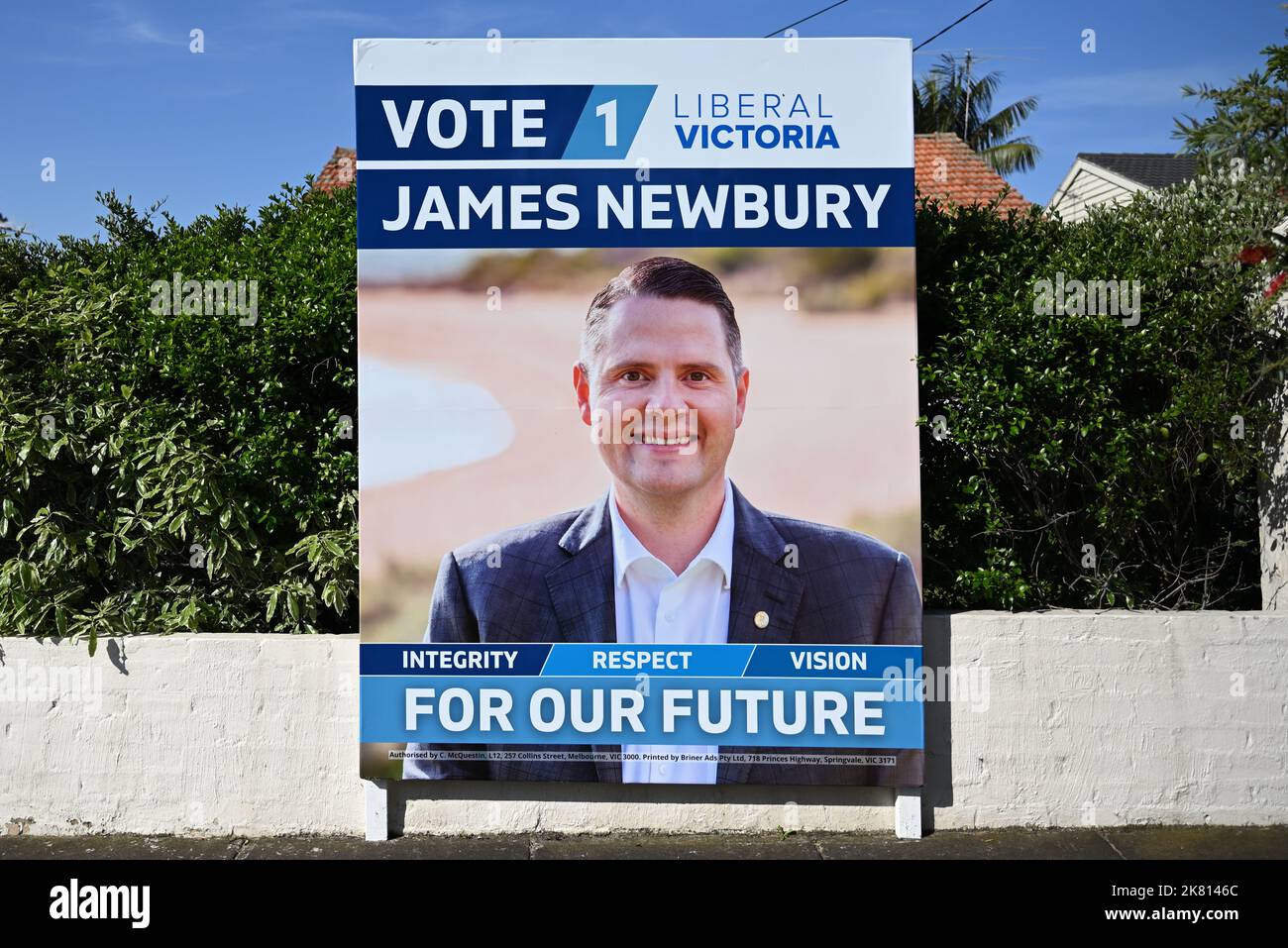Large blue and white campaign sign, on a fence, urging people to vote ...