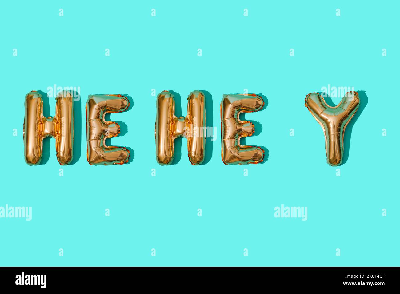 some golden letter-shaped balloons forming the word hey but as ...