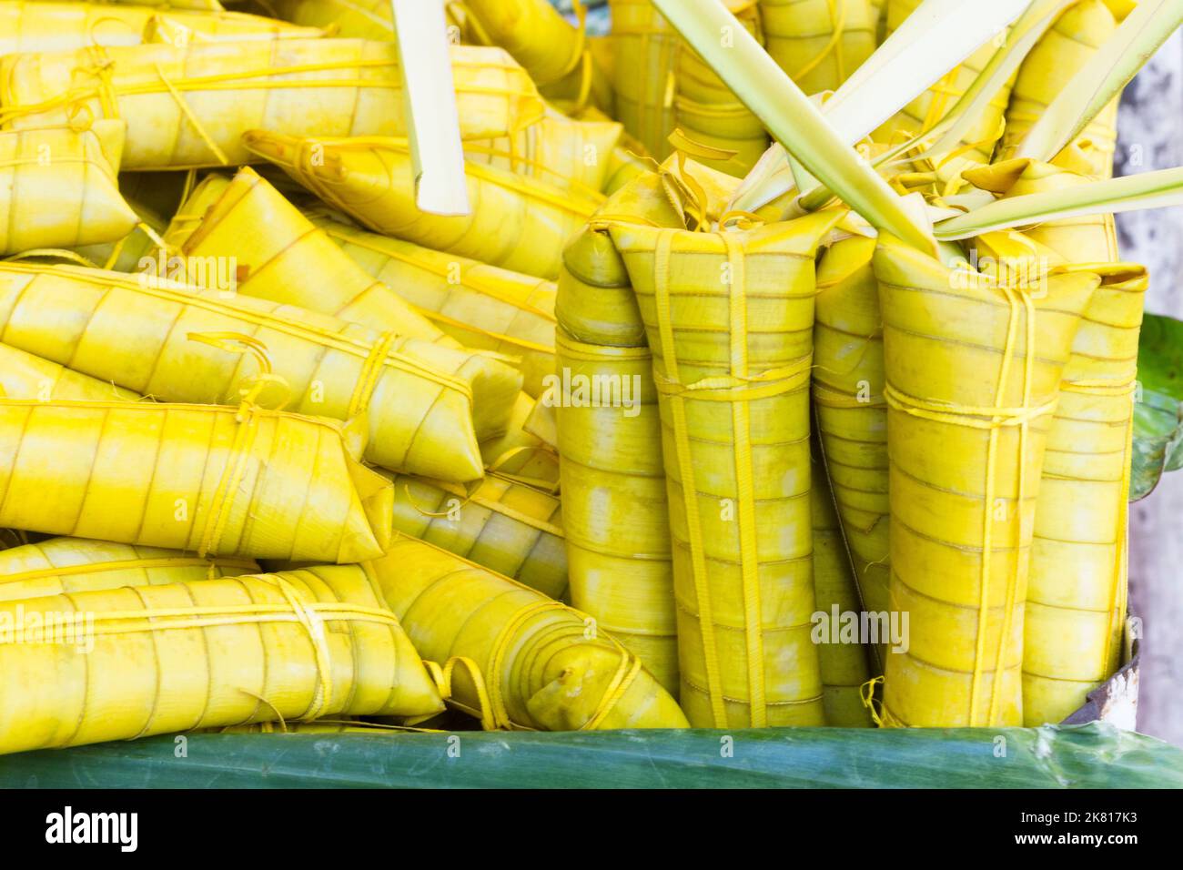 Traditional rice cakes wrapped in coconut leaves at a market in ...