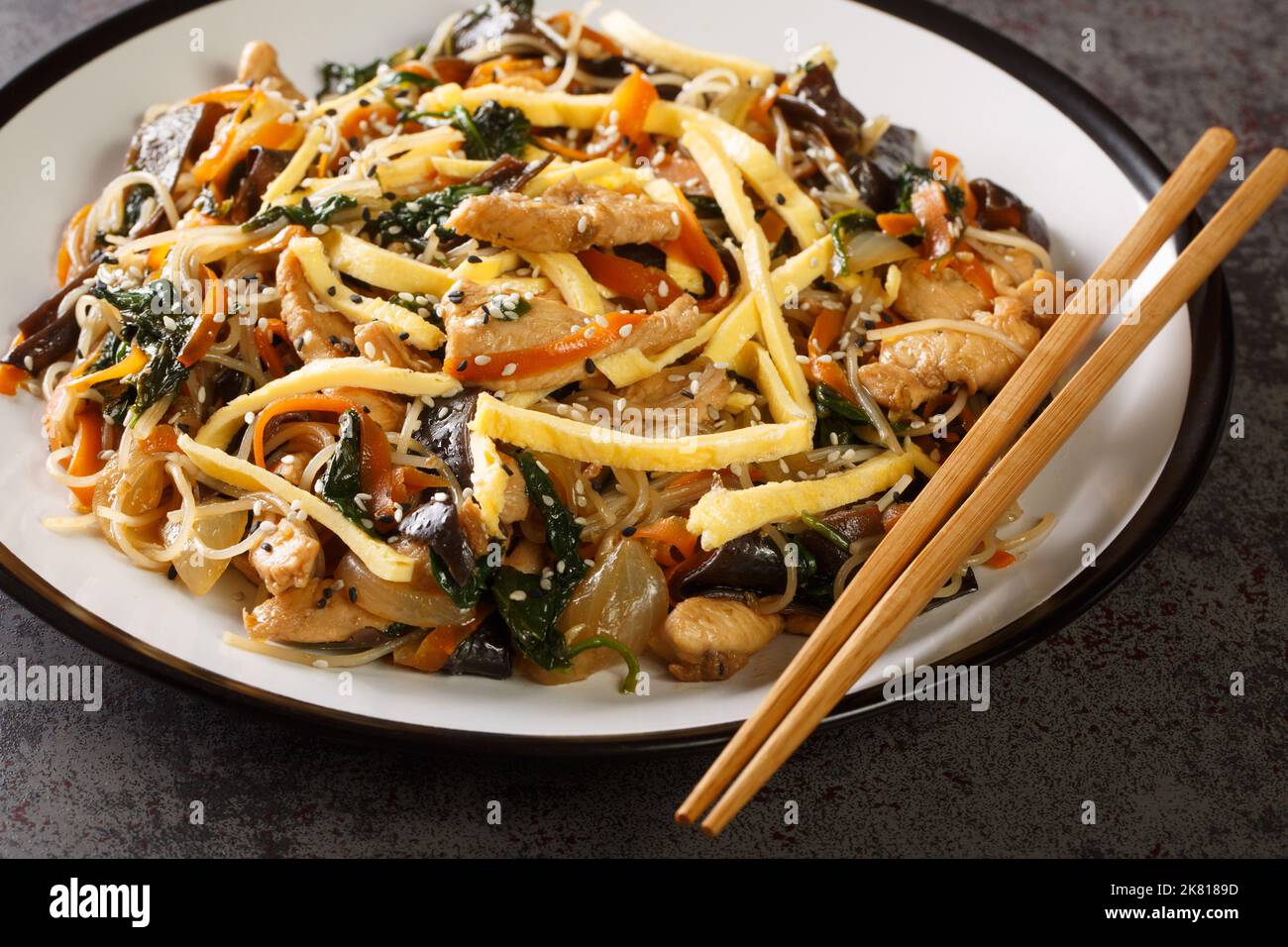 Korean Japchae Stir-fried glass noodles and vegetables closeup on the ...