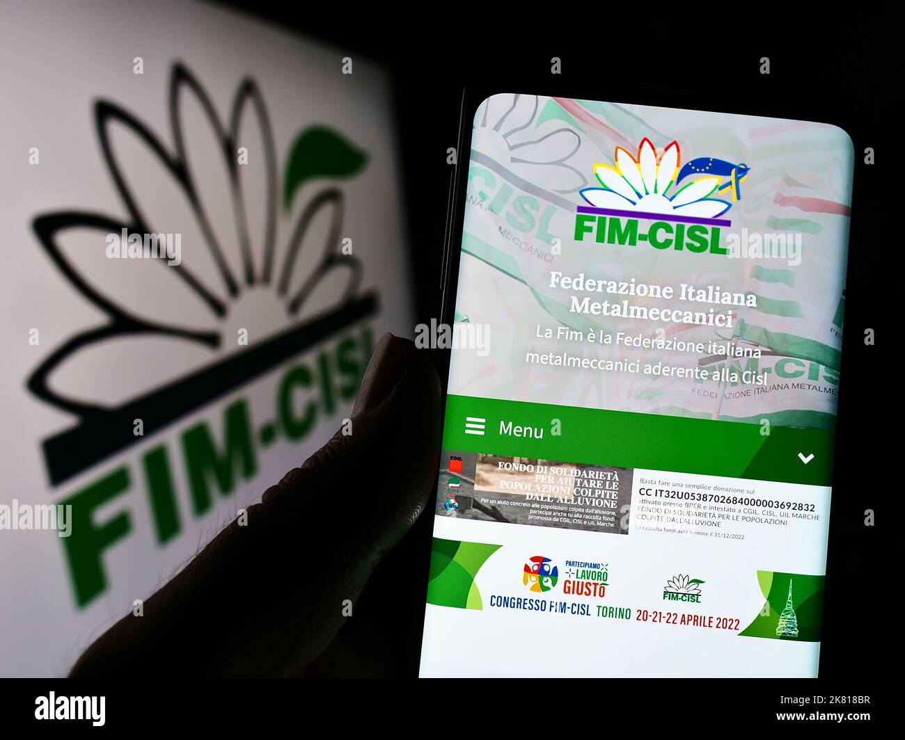 Person holding cellphone with website of Italian trade union FIM-CISL ...