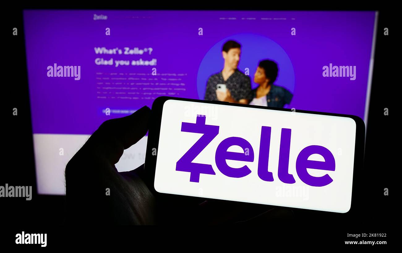 Person holding cellphone with logo of US digital payments company Zelle ...