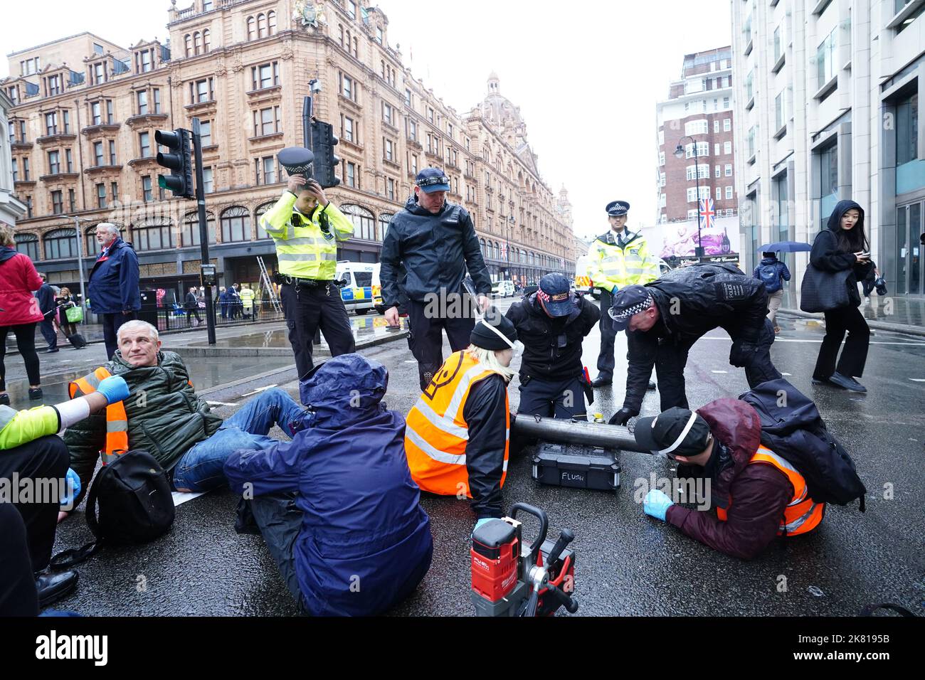 Police officers deal with activists from Just Stop Oil during their ...
