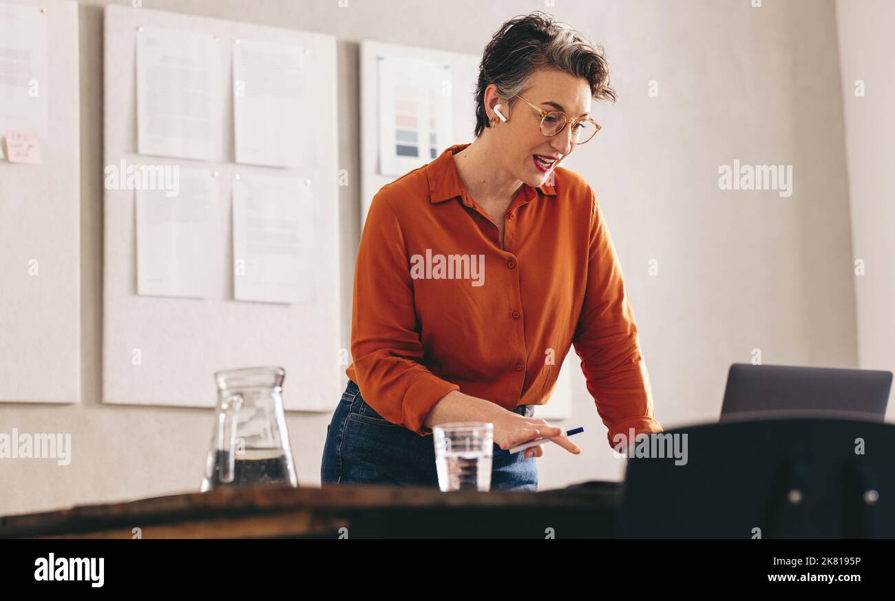 Mature businesswoman talking to her client during a video conference ...