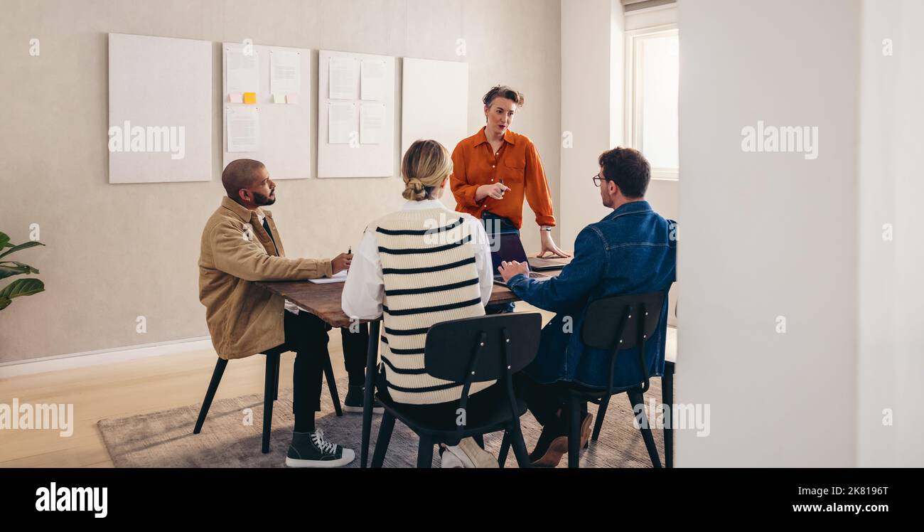 Mature team leader having a discussion with her colleagues during a ...