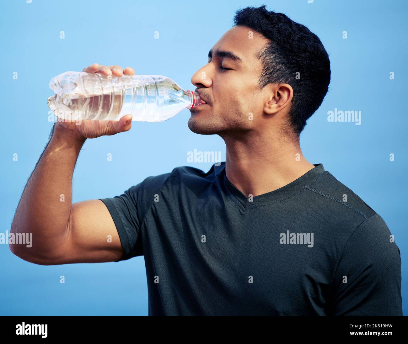 Stay hydrated so you dont lose energy. a sporty young man drinking ...