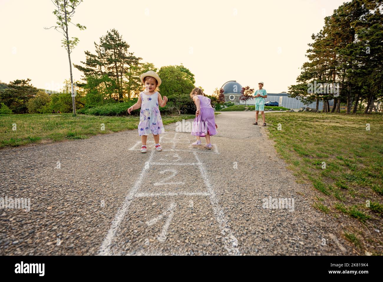 Two sisters playing hopscotch in park. Kids game, children outdoor ...