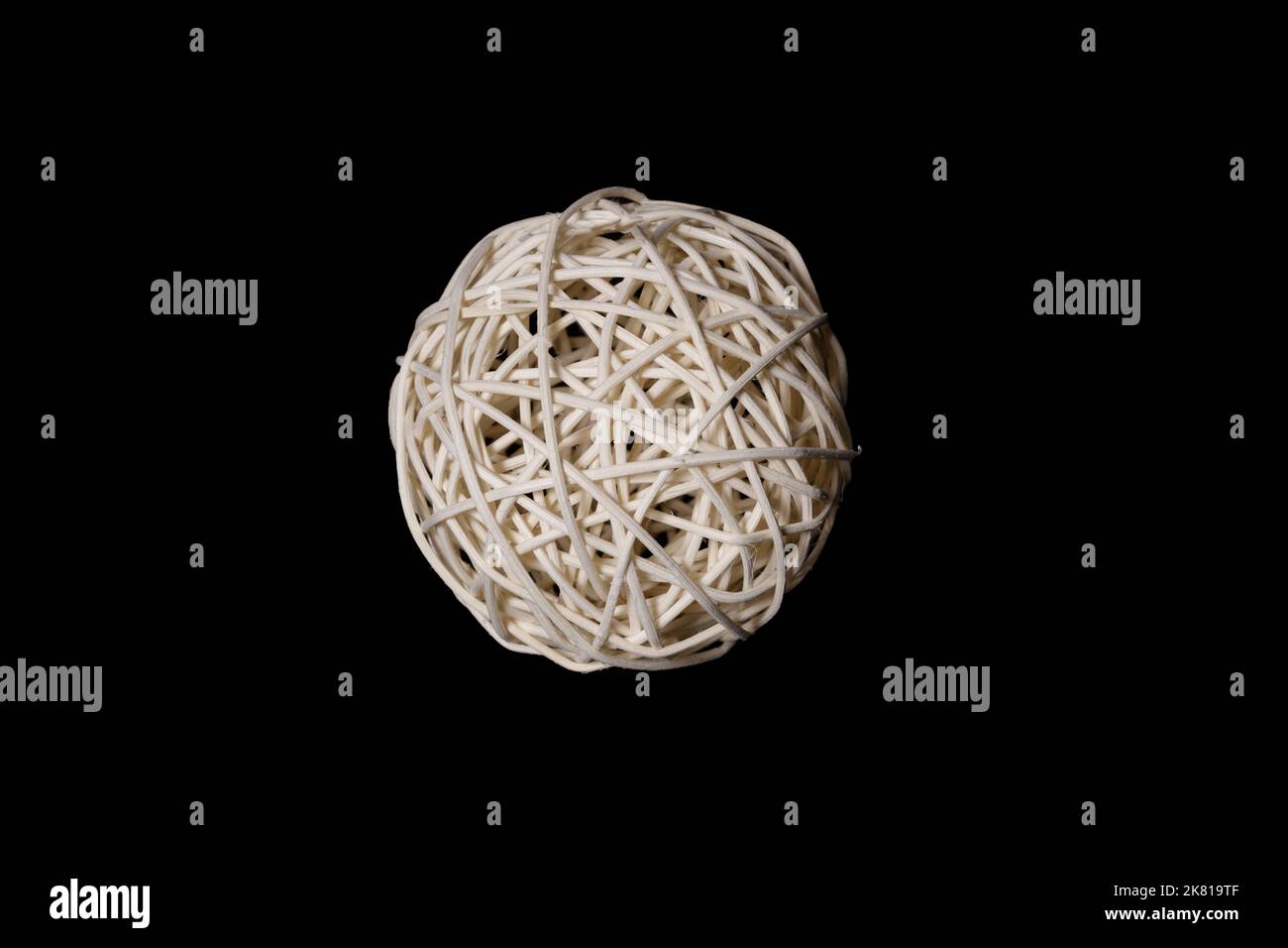 a ball woven from a wooden vine of bamboo on a black background Stock ...