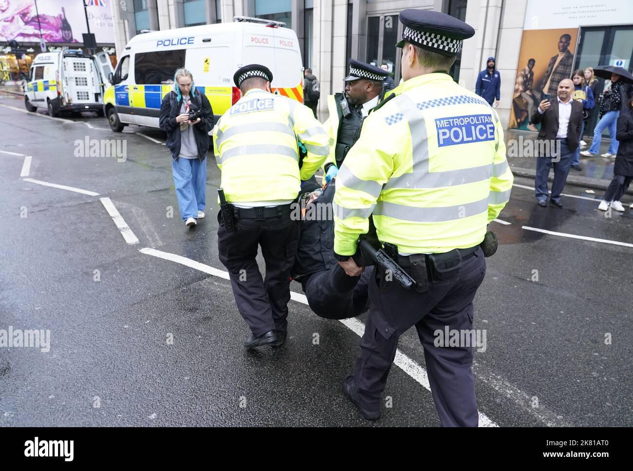 Police officers deal with activists from Just Stop Oil during their ...