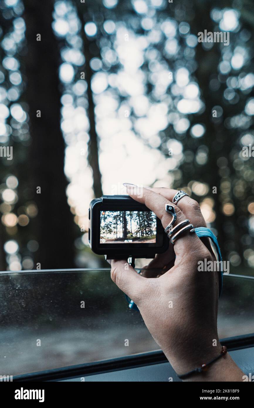 A shallow focus shot of woman hand holding small camera shooting ...