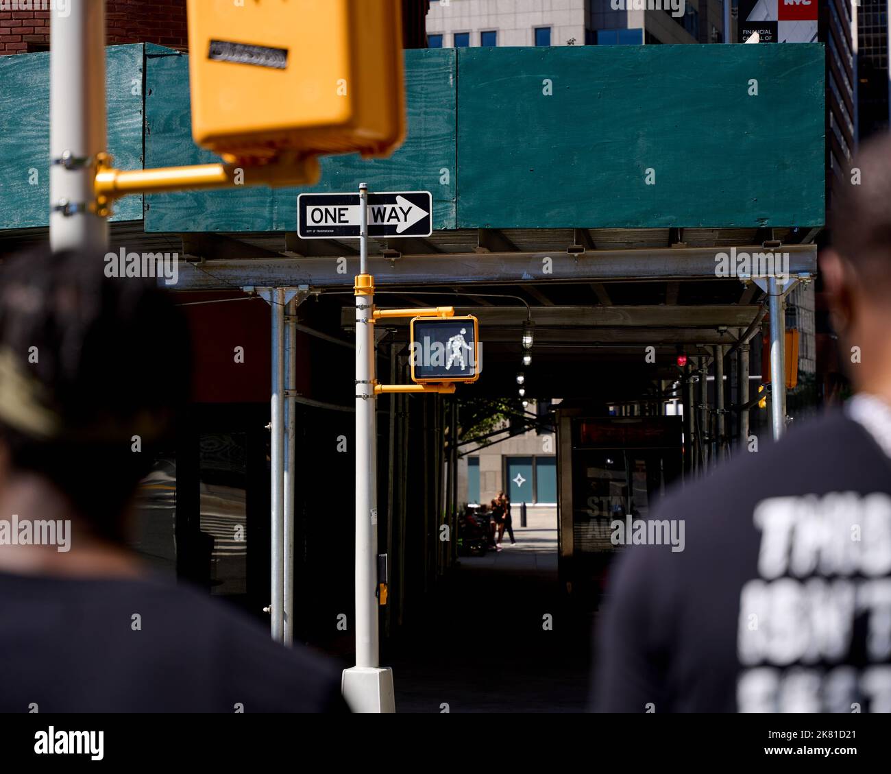 A ONE WAY road sign in New York City with a view through stret ...