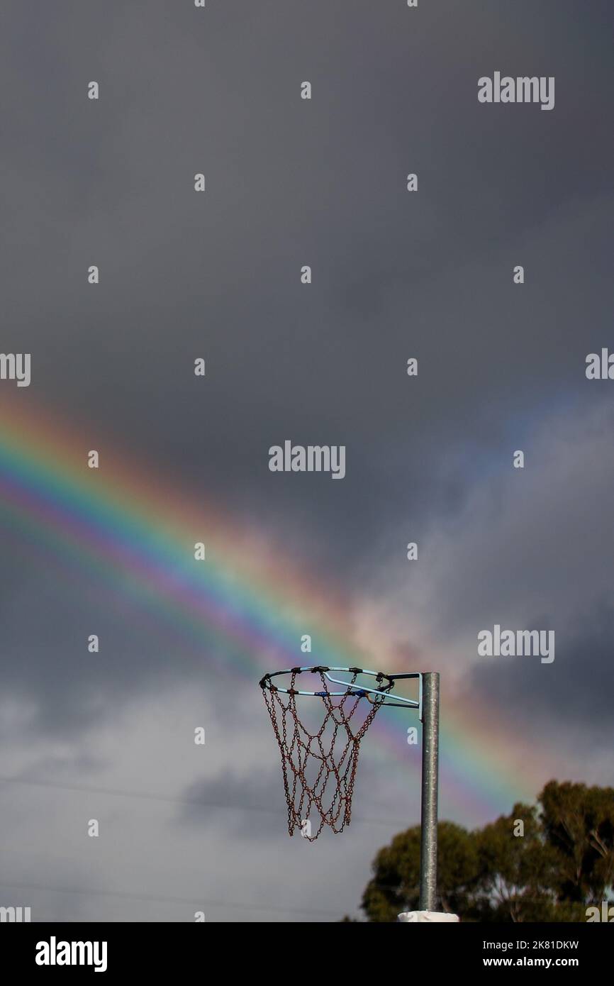 A vertical shot of a netball ring against Rainbow in the sky Stock ...