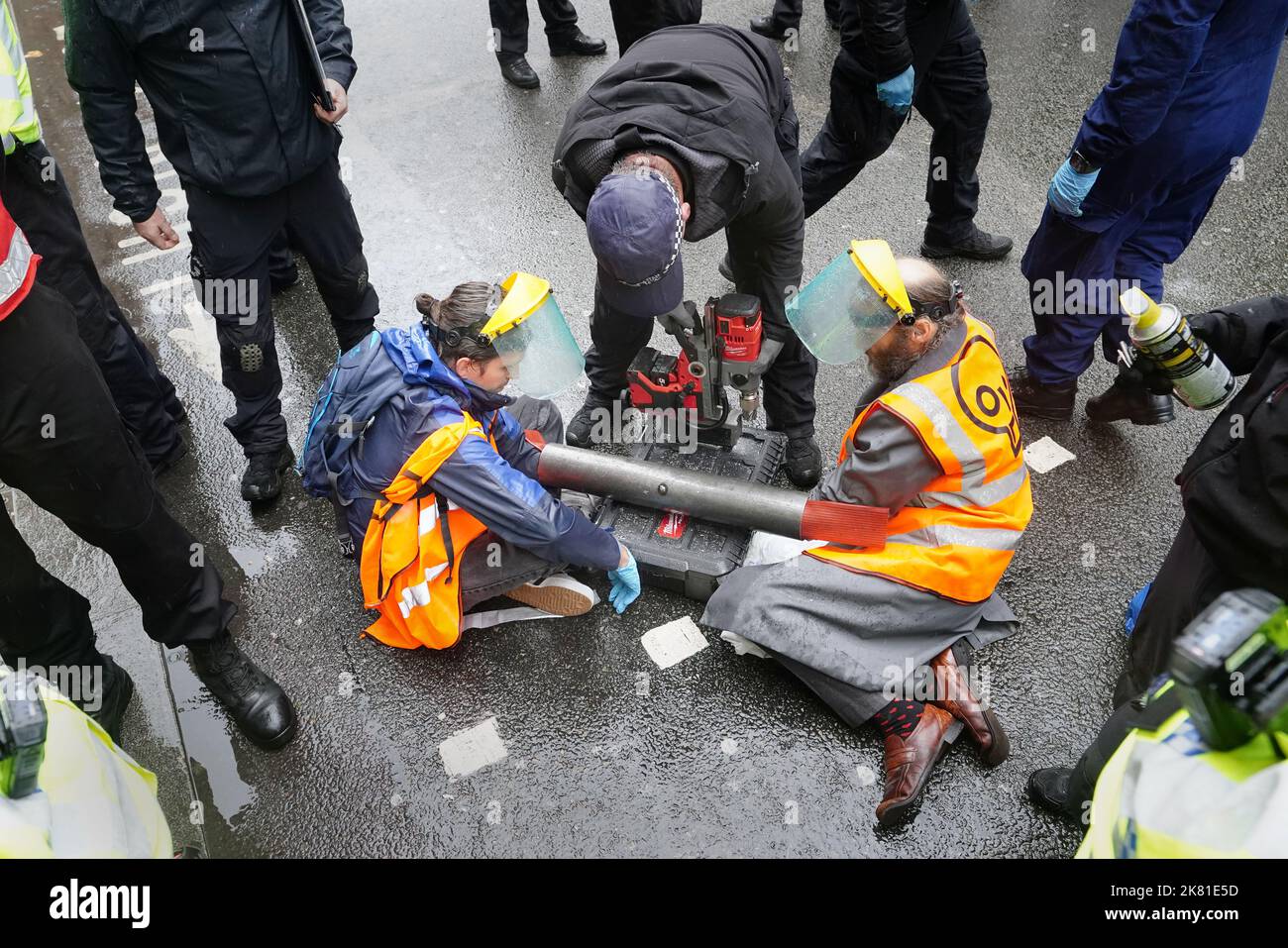 Police officers deal with activists from Just Stop Oil during their ...