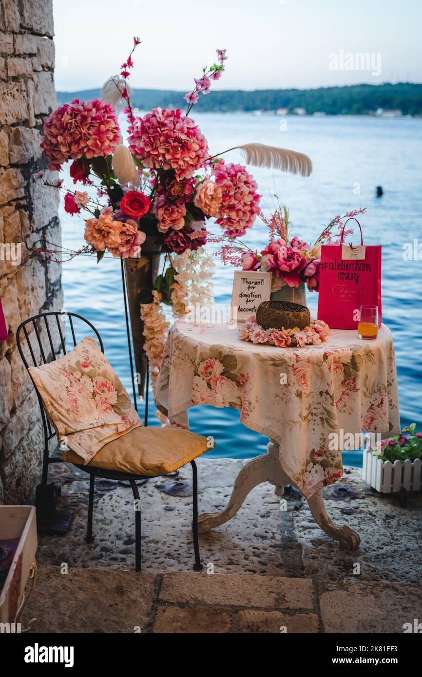 A vertical shot of a romantic cafe table at the shore in a narrow ...