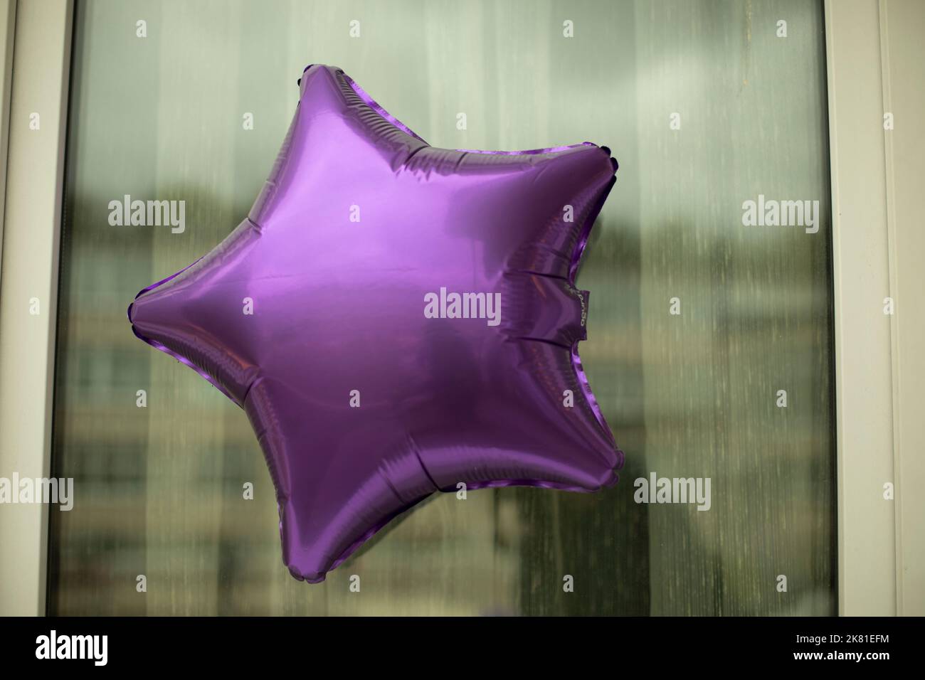 Balloon star. Purple inflatable ball. Star on window. Exterior ...