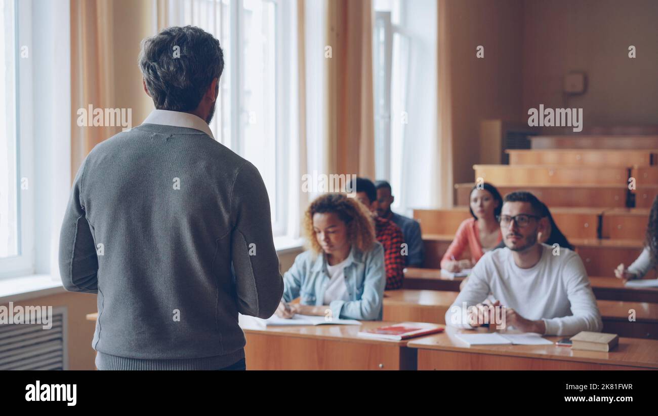 Bearded mature man professor is reading lecture talking and gesturing ...