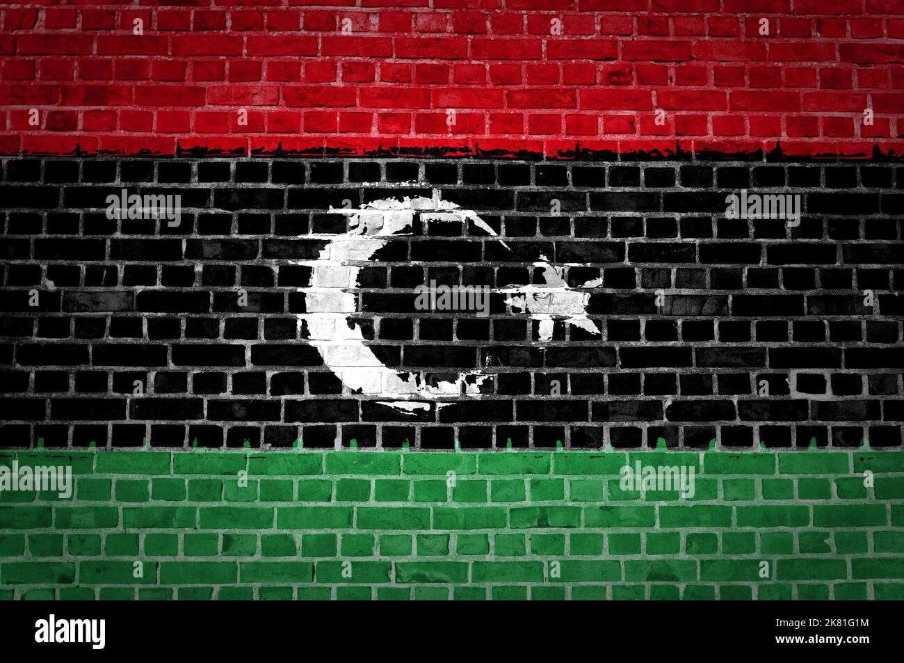 An image of the Libya flag painted on a brick wall in an urban location ...