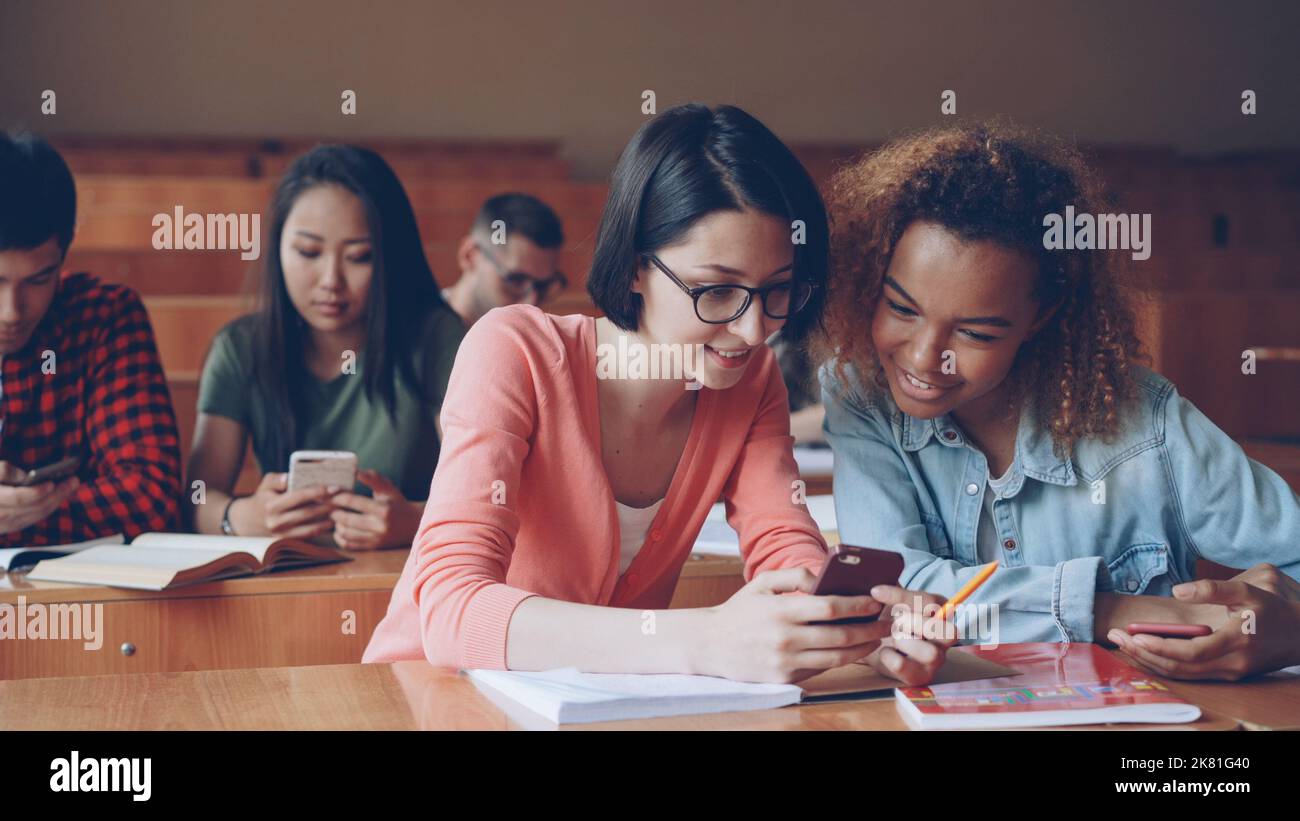 Pretty girls students students are using smartphone, watching screen ...