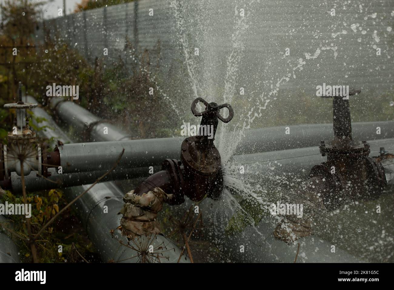 Pipe breaking with water. Pipeline accident. Hot water flows from pipes ...