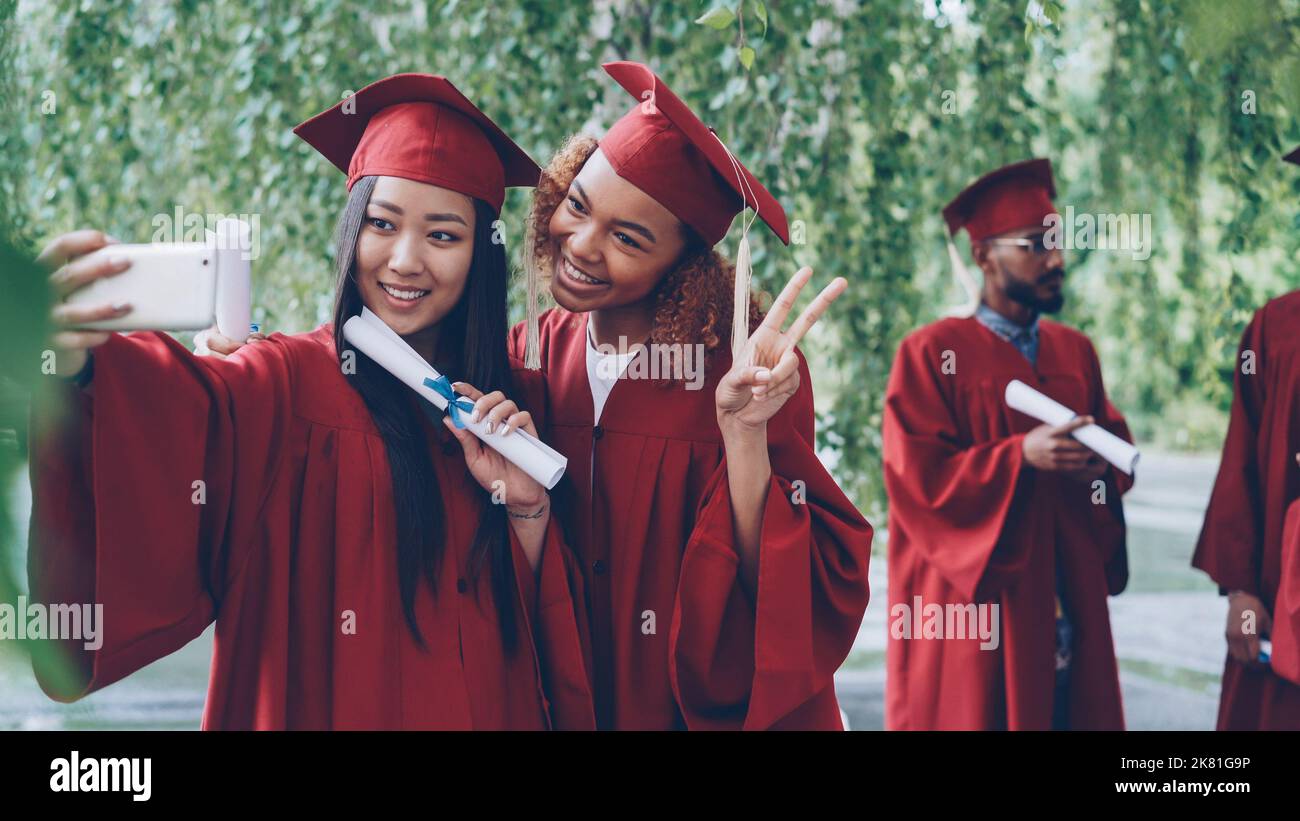 Two attractive girls fellow students are taking selfie with smartphone ...