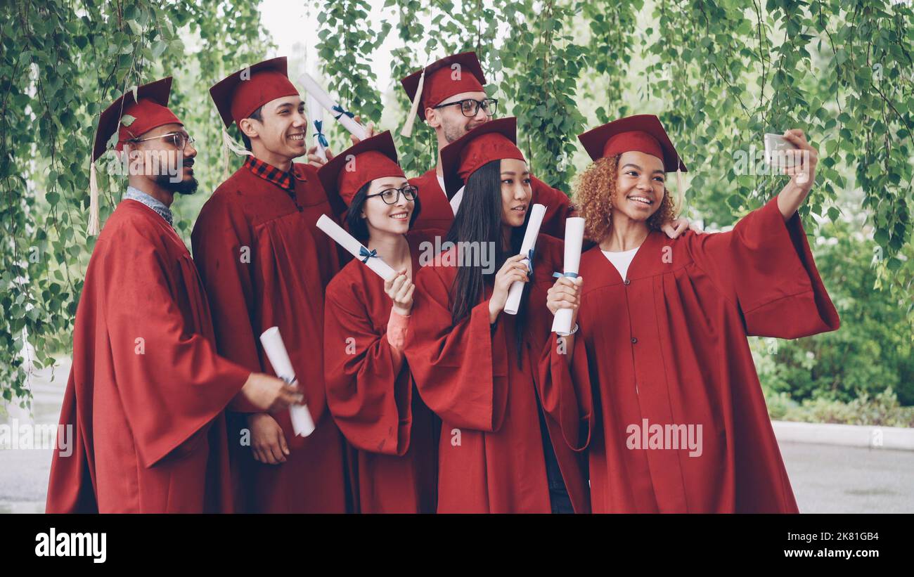 Excited graduating students are taking selfie with smartphone, young ...