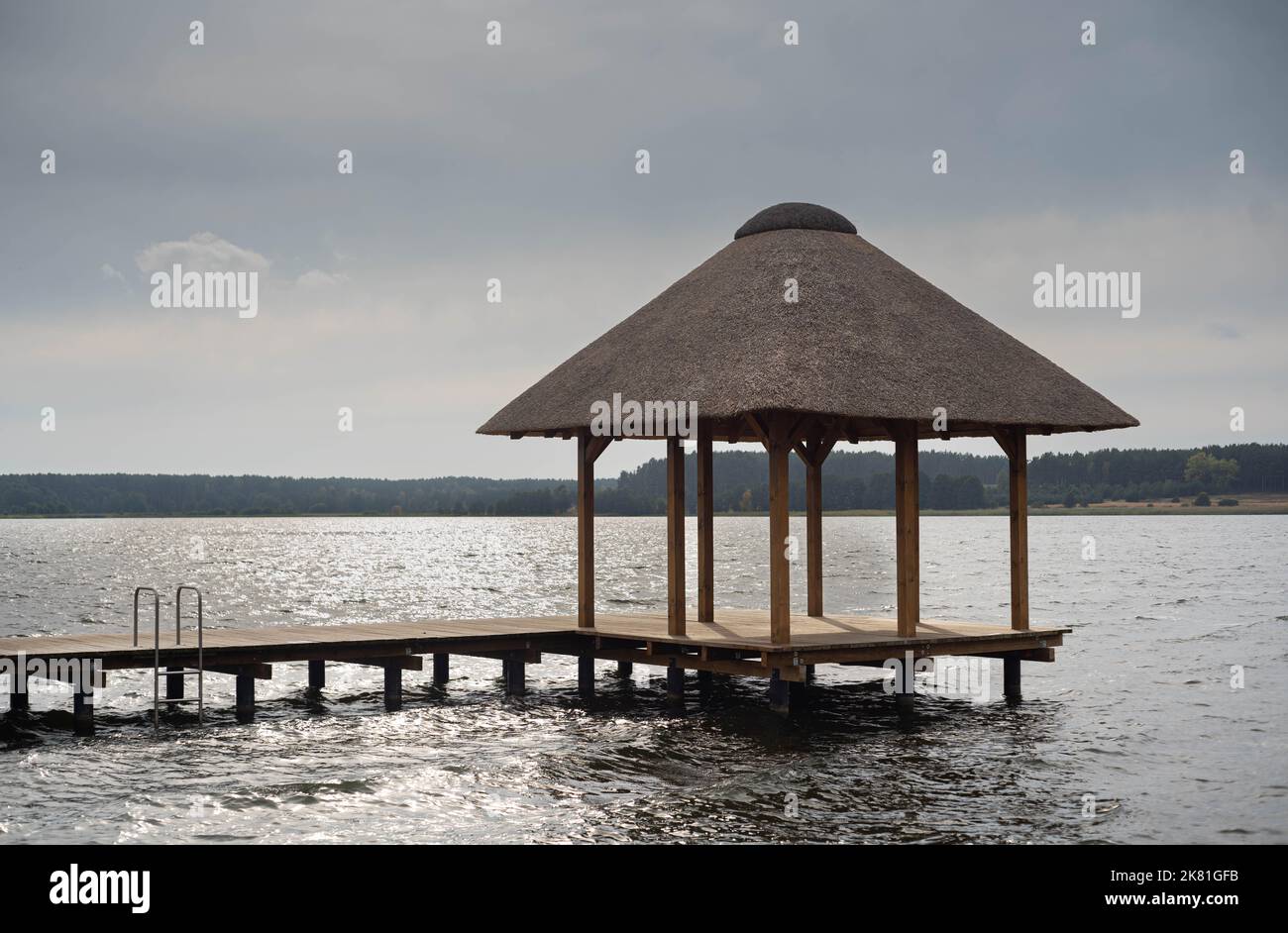 A beautiful seascape with a small pavilion on a wooden dock in cloudy ...