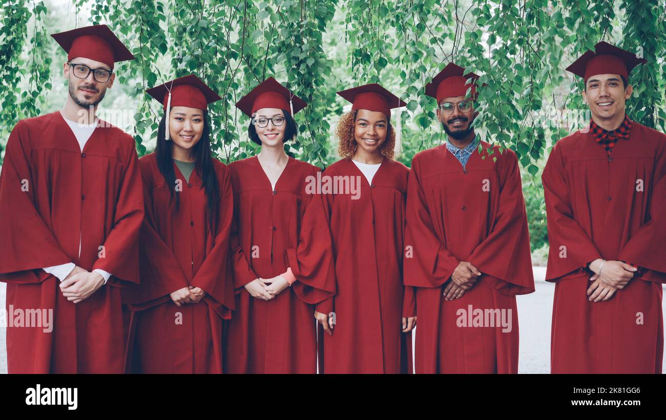 Portrait of multiethnic group of graduating students standing outdoors ...