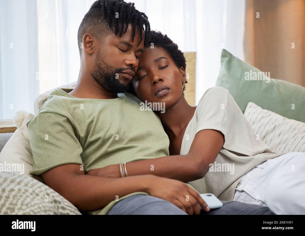 Who doesnt like a weekend nap. a young couple taking a nap on the couch ...