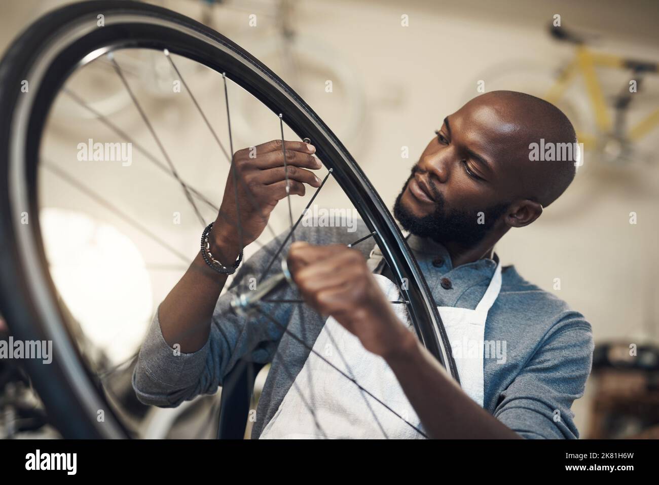 You see a bike, I see greener grass. a young man fixing a wheel at a bicycle repair shop Stock ...