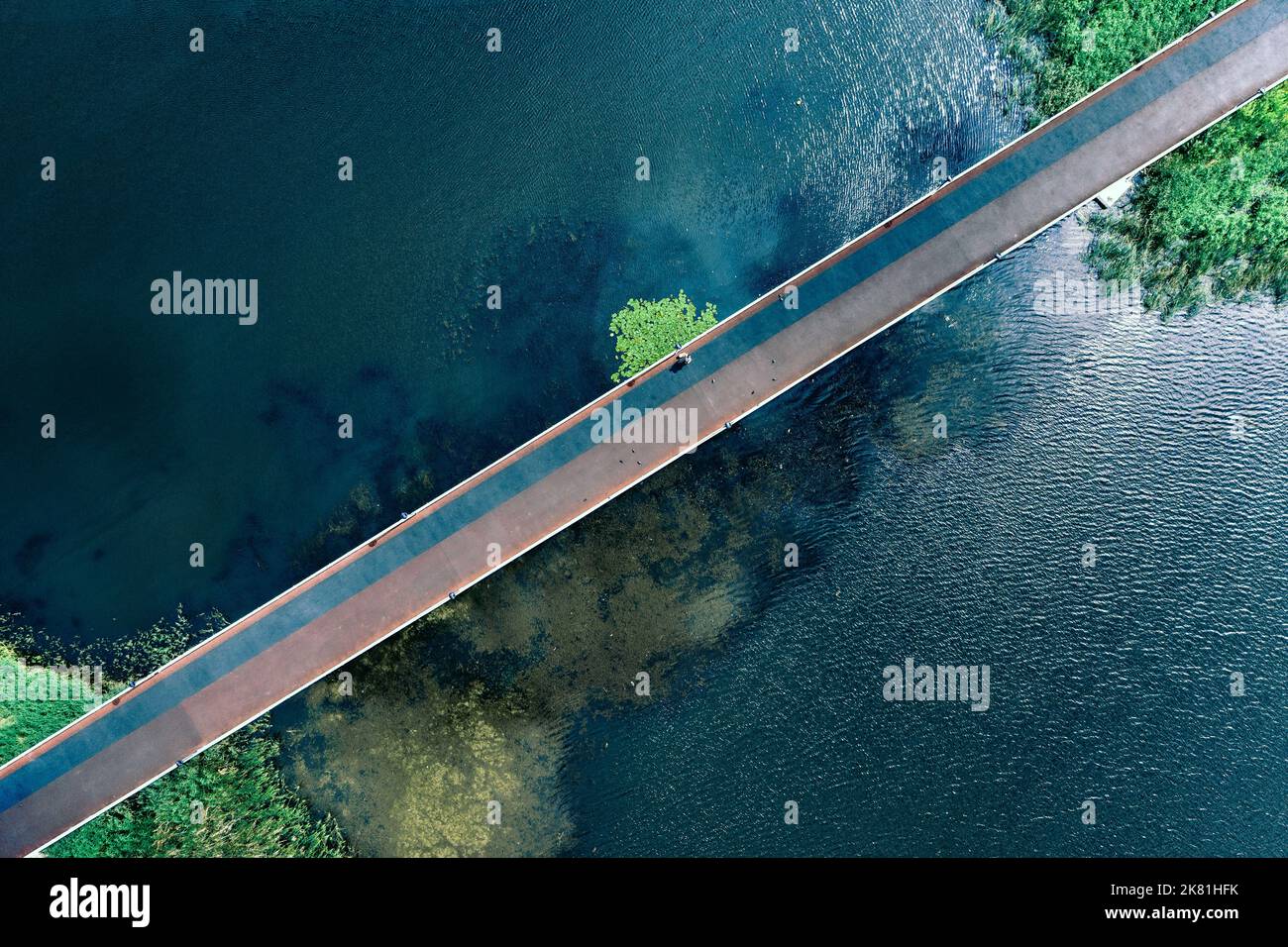 Top view of footbridge across amazing blue ripples water texture pond ...