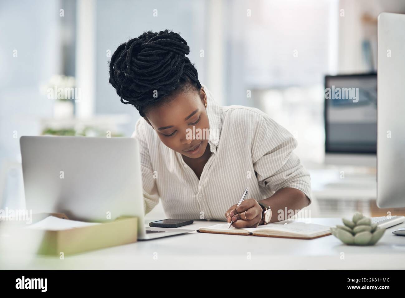 Working hard to achieve my goals. a businesswoman writing in her ...