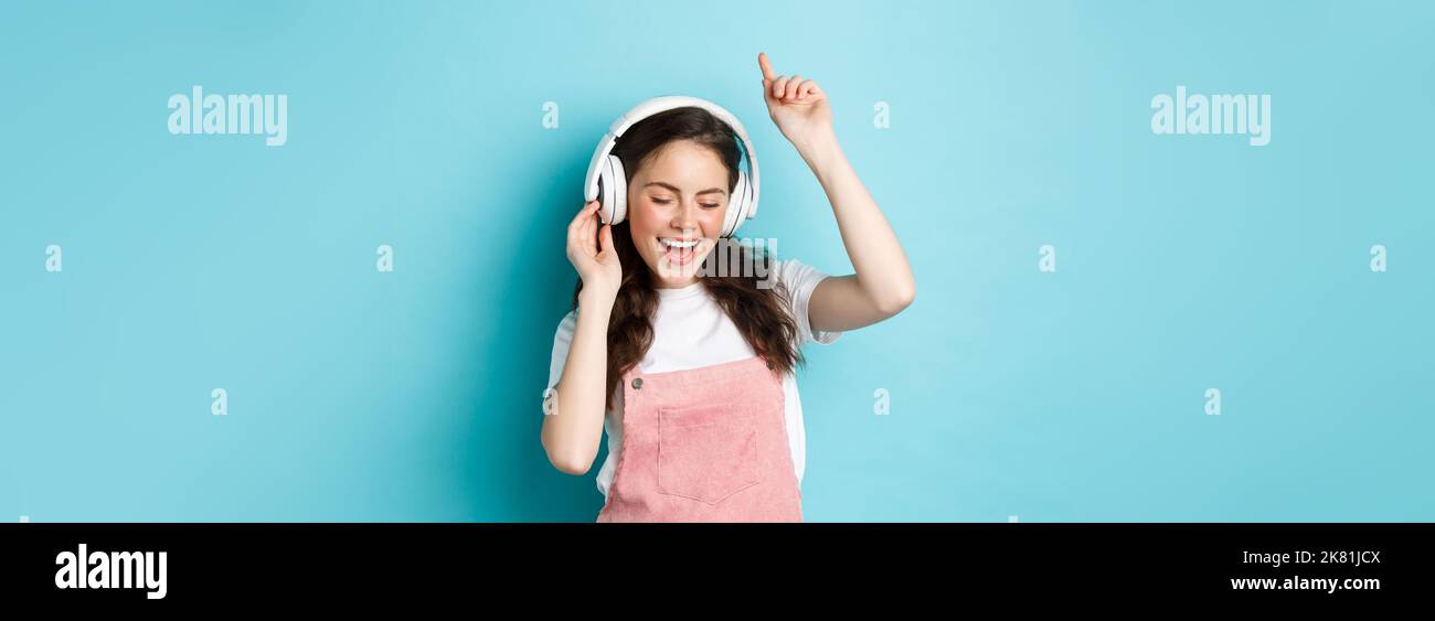 Stylish millennial girl dancing in spring outfit, listening music in ...