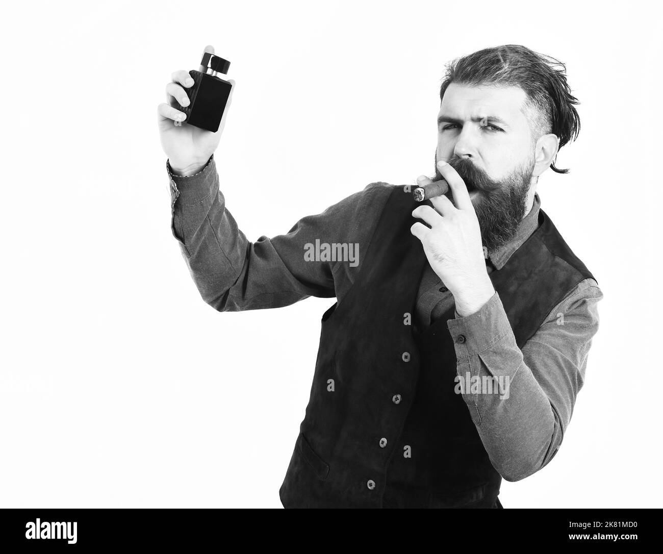 bearded man smoking cigar with serious face, holding perfume Stock ...