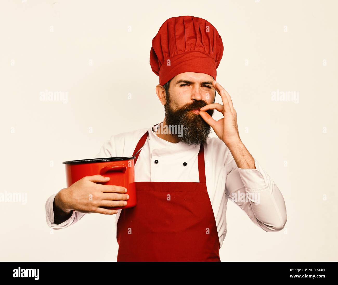 Cook with satisfied face in burgundy uniform has casserole Stock Photo ...