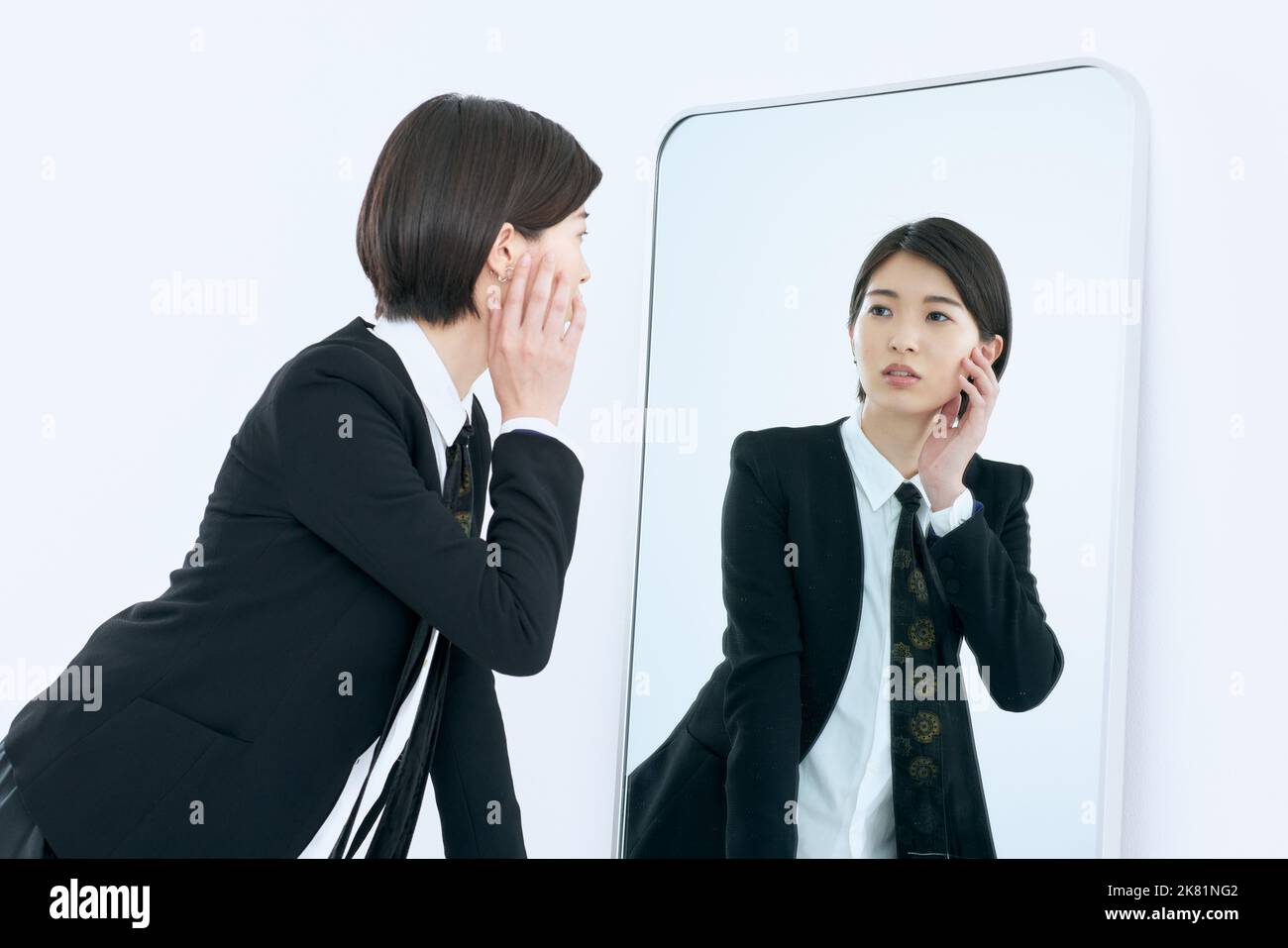 Young Japanese woman looking in the mirror Stock Photo - Alamy