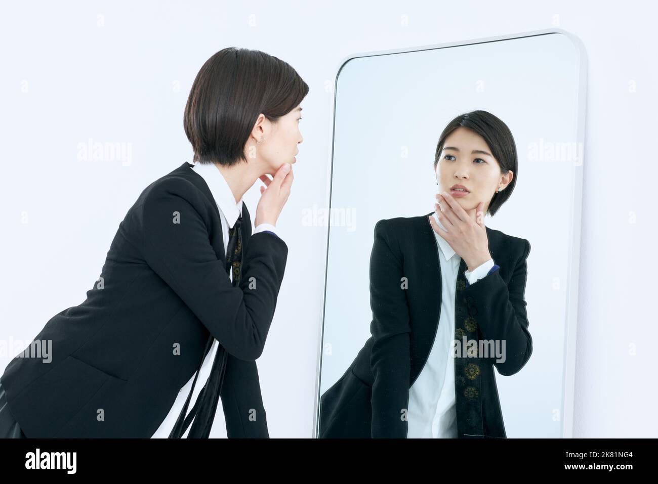 Young Japanese woman looking in the mirror Stock Photo - Alamy