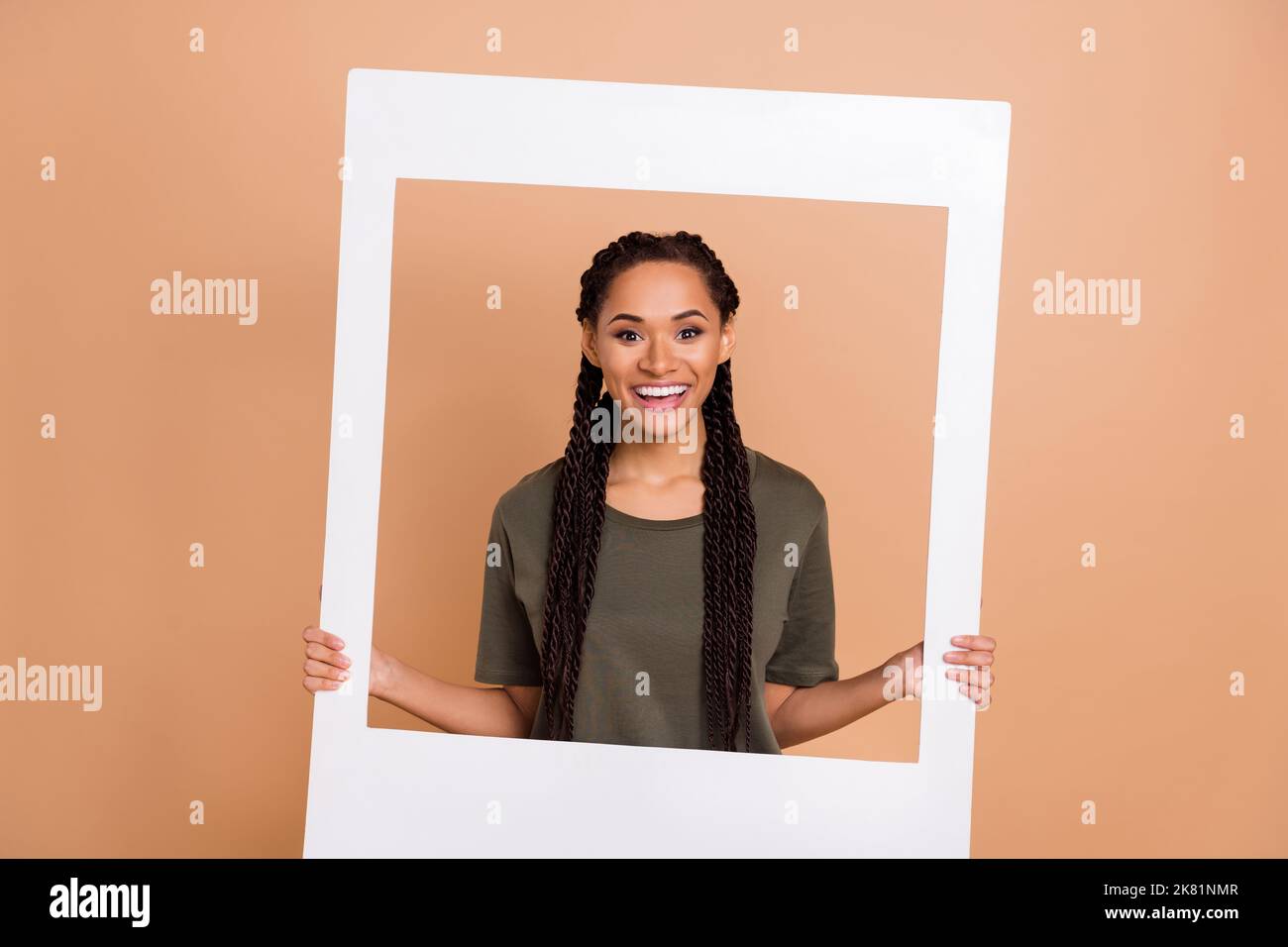 Portrait of pretty positive girl toothy smile look through paper album ...