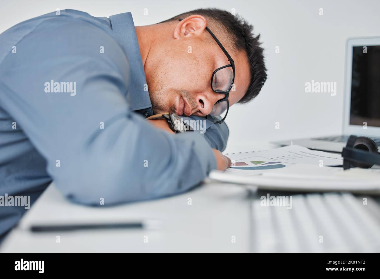 Work has me working overtime. a handsome young businessman sleeping on ...