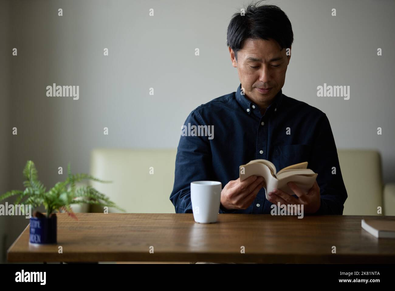 Japanese man reading a book Stock Photo - Alamy