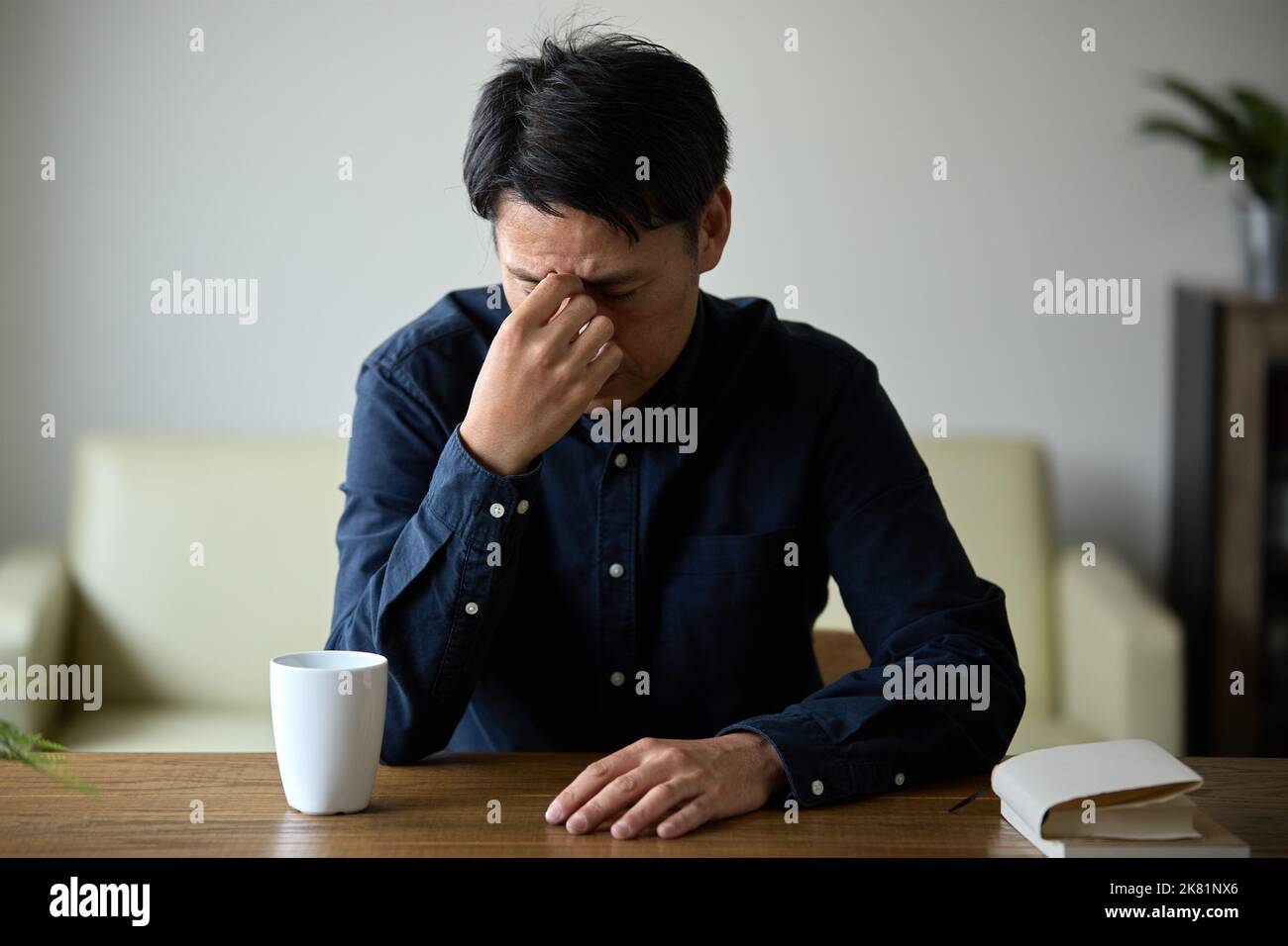 Tired Japanese man at home Stock Photo - Alamy