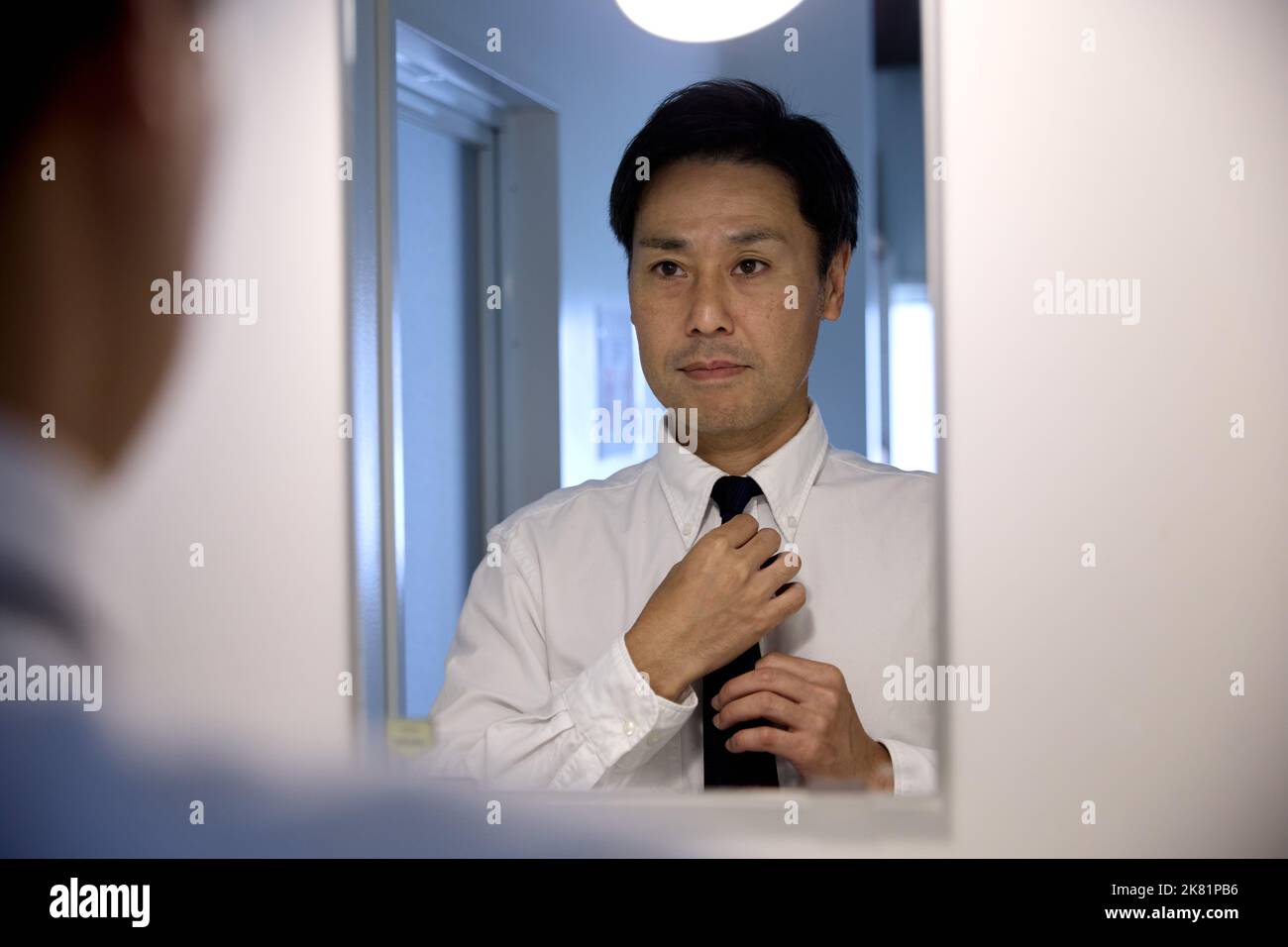 Japanese man tying a tie Stock Photo - Alamy